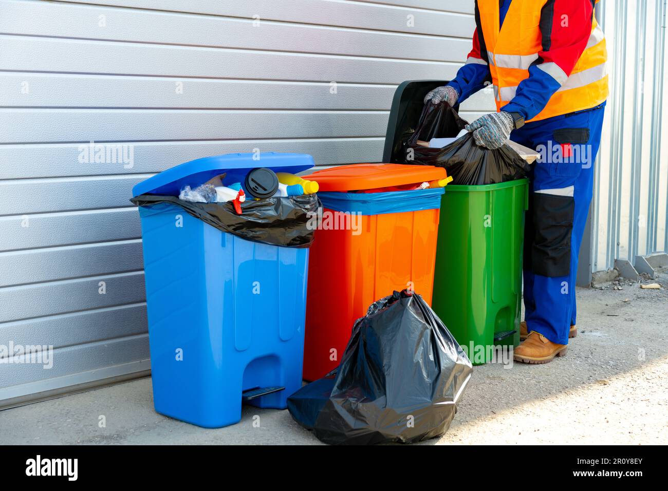 Janitor takes garbage out of trash container outdoors Stock Photo - Alamy