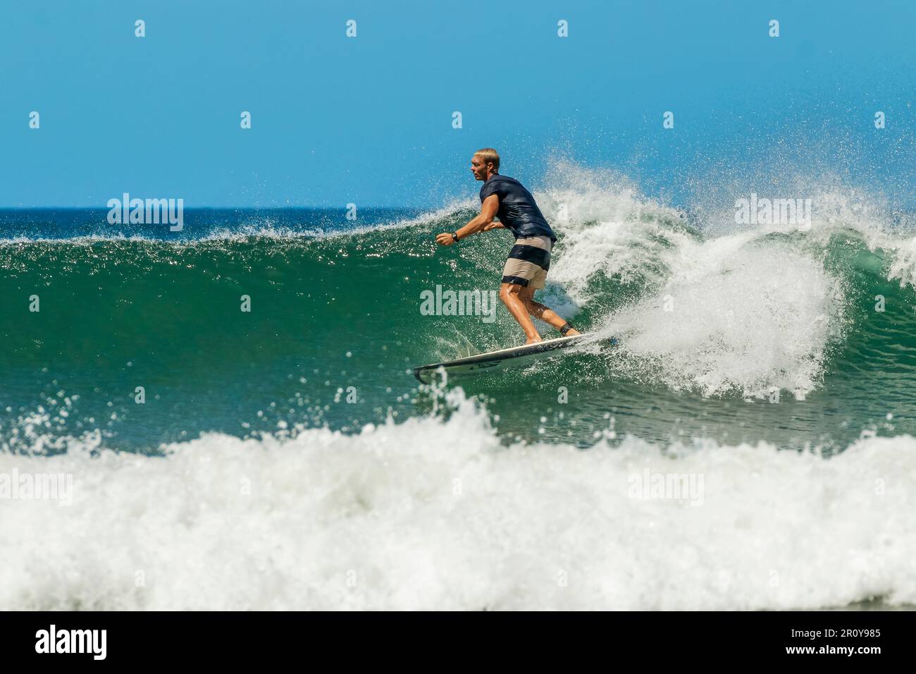 Stand up paddleboarder surfing on the face of a wave at this popular ...