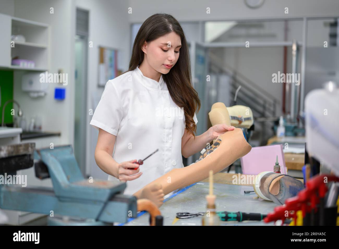 Technician holding prosthetic leg checking and working in laboratory ...
