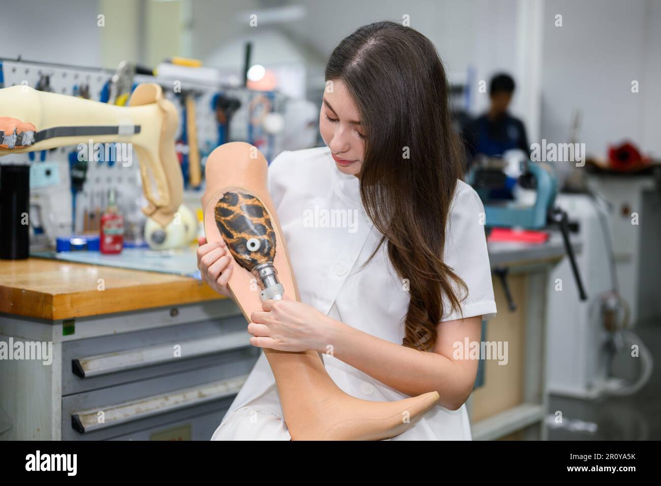 Technician holding prosthetic leg checking and working in laboratory ...
