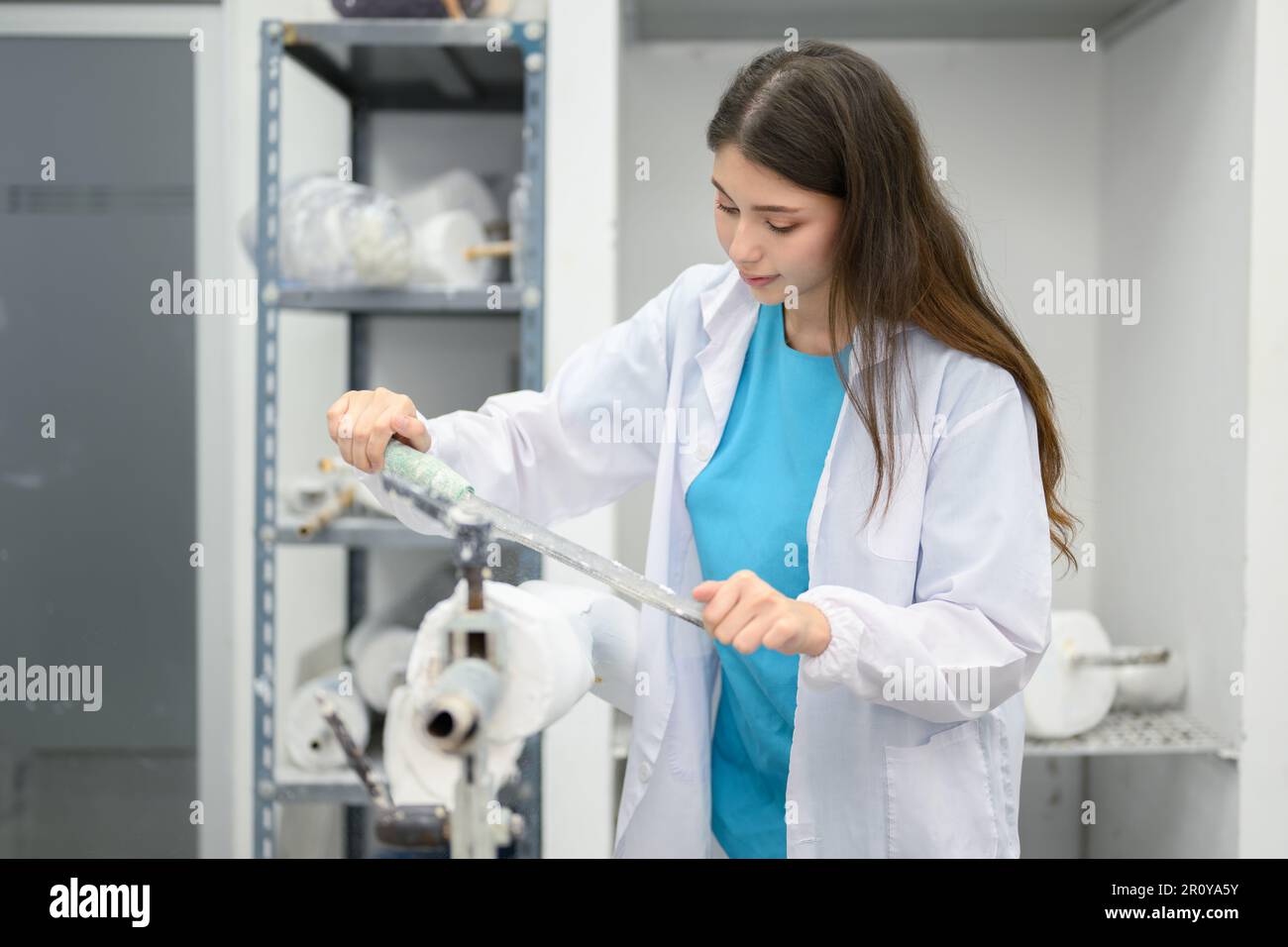 Technician making prosthetic device using grinder to smooth socket ...
