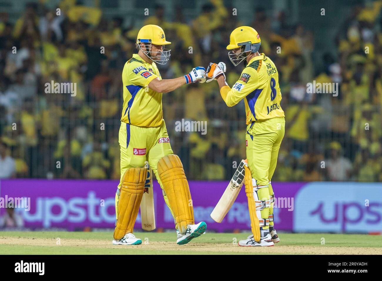 Chennai Super Kings' captain MS Dhoni, left, touches gloves with teammate Ravindra Jadeja during ...