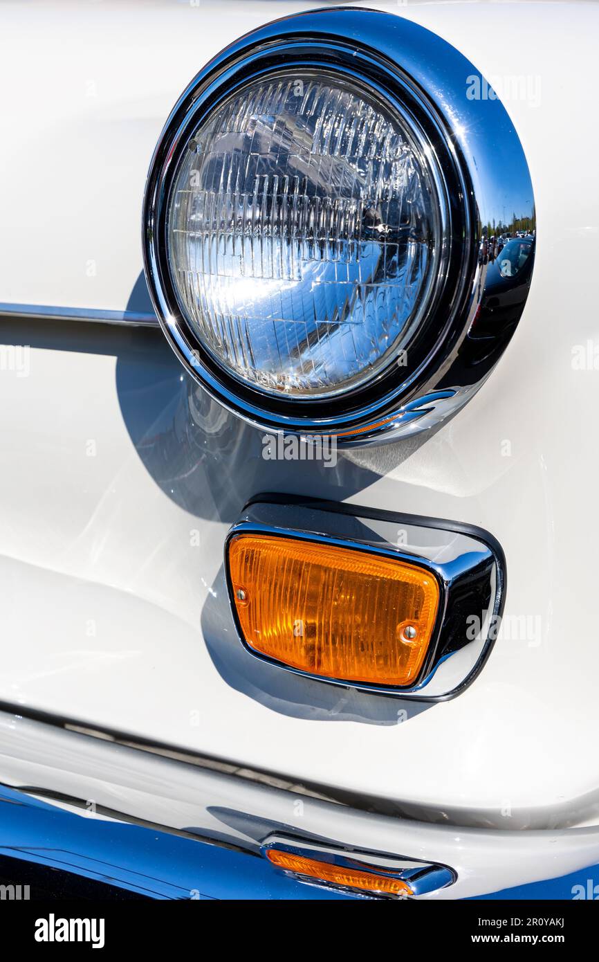 Close-up of the round headlamps and orange turn signal of a white ...