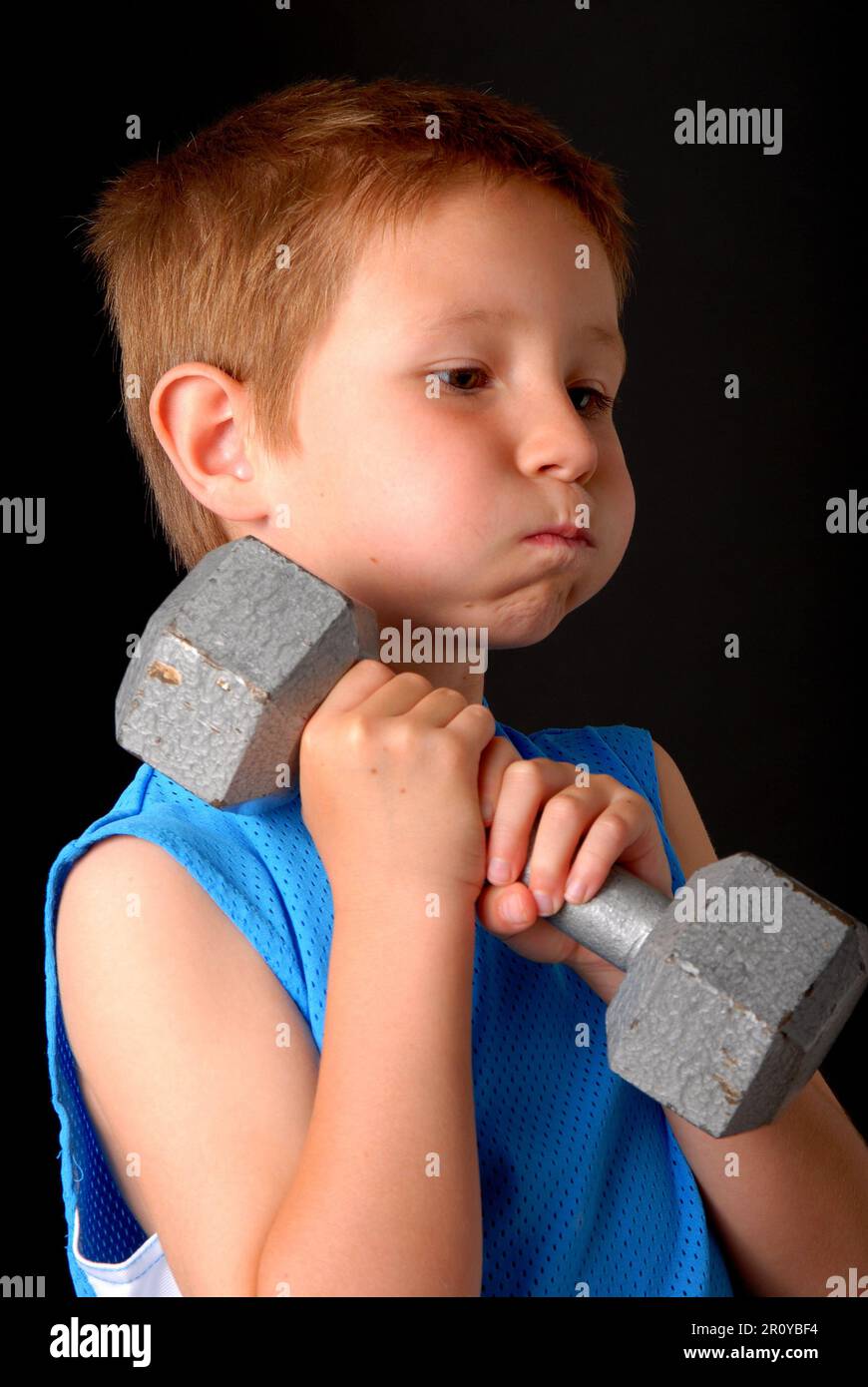 Young boy lifting weight that is too heavy Stock Photo - Alamy
