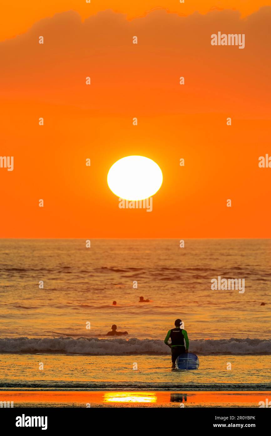 Surfer with longboard at sunset on Guiones Beach, at this popular hip ...