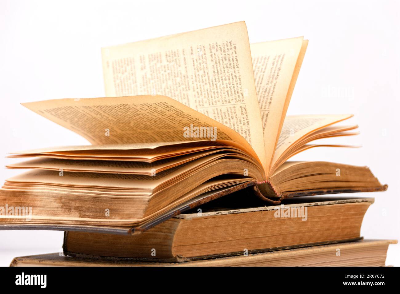 vintage old open book with some visible pages lying on top of other ...