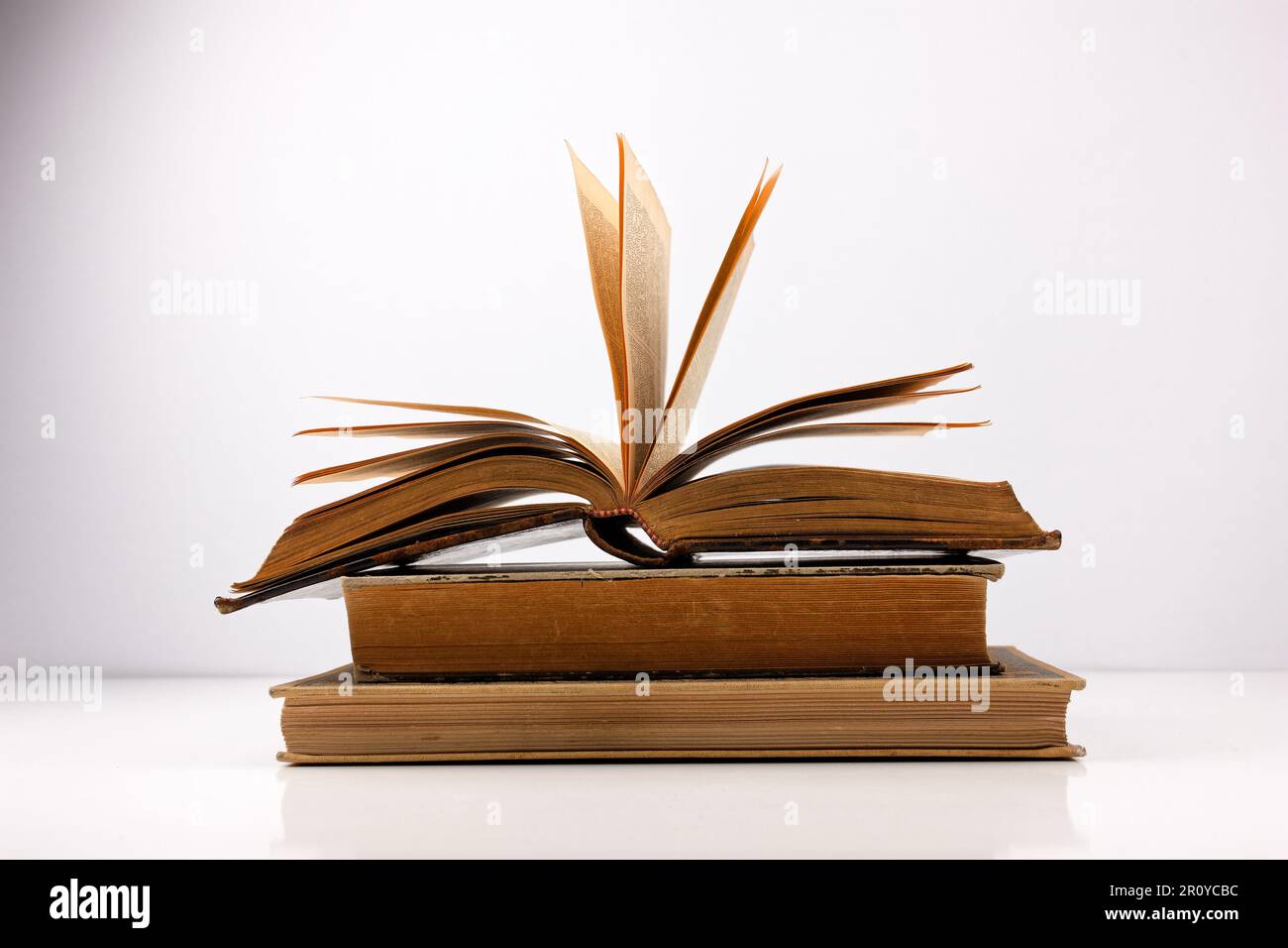 vintage old open book with some visible pages lying on top of other ...