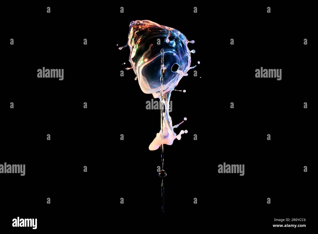 Falling drops of colored liquid, water splashes on a black background ...
