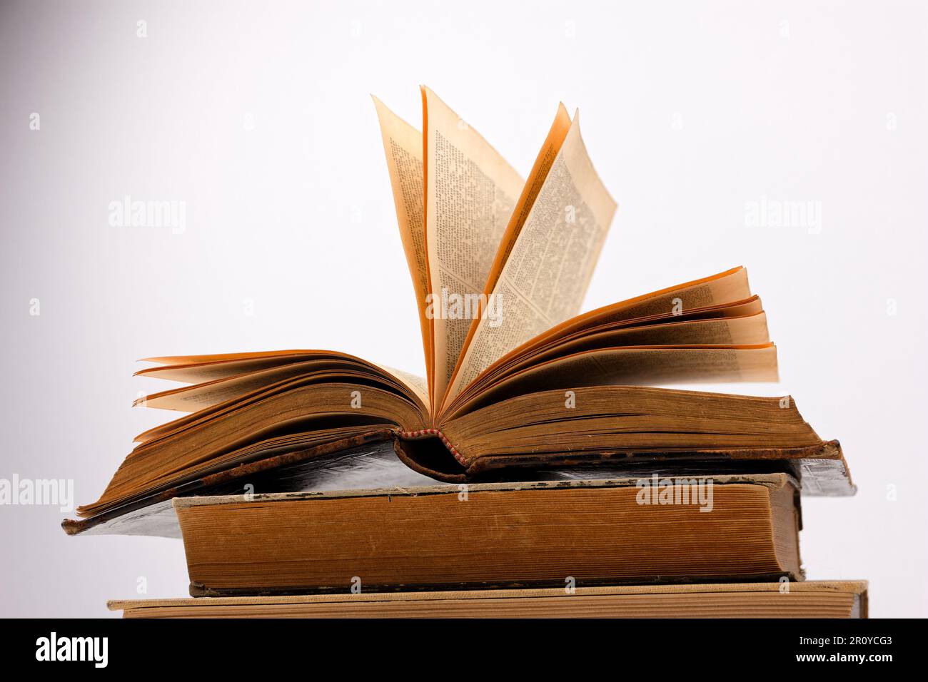 vintage old open book with some visible pages lying on top of other ...