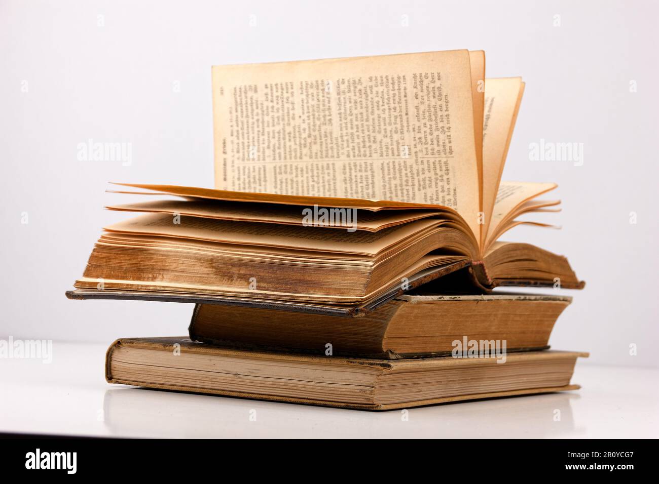 vintage old open book with some visible pages lying on top of other ...