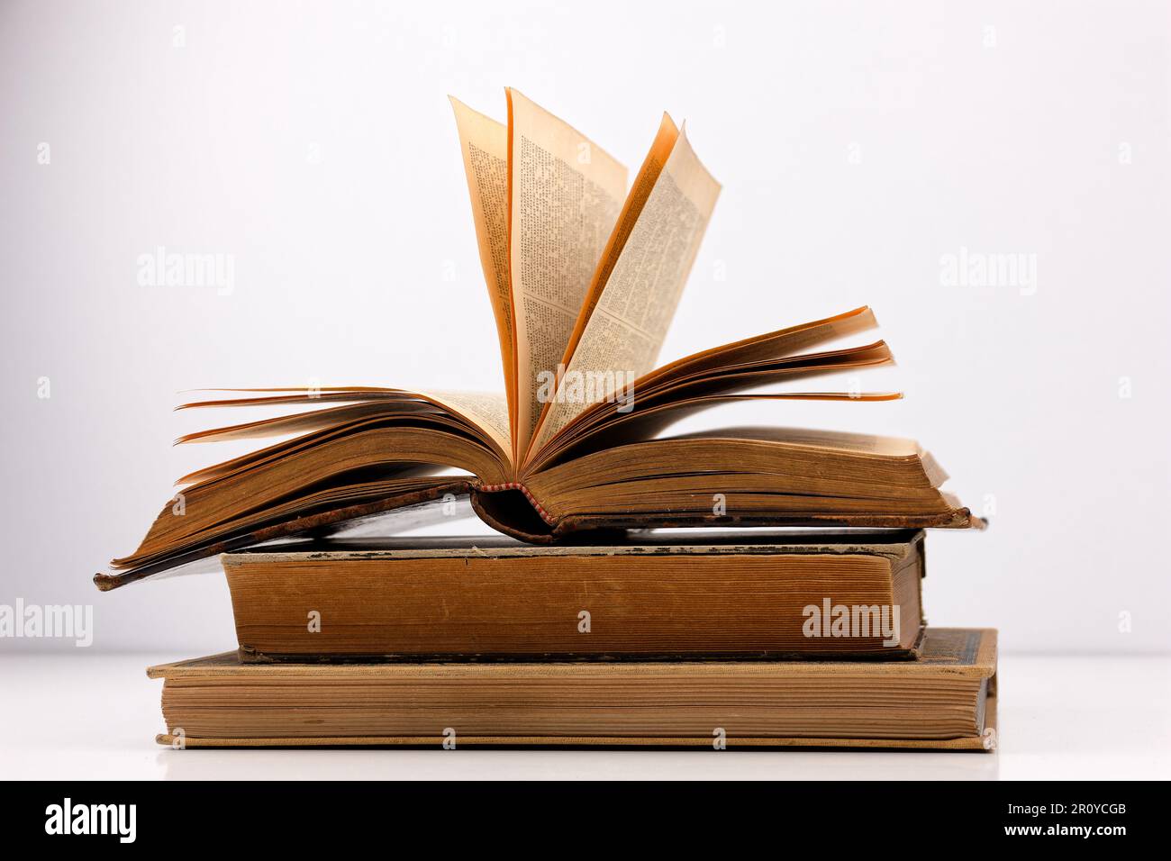 vintage old open book with some visible pages lying on top of other ...