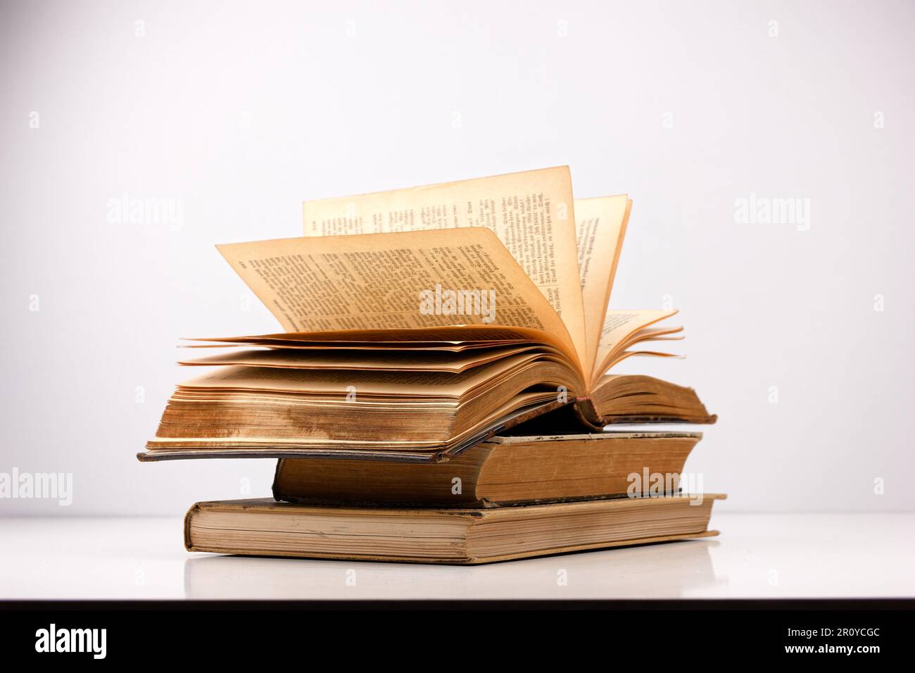 vintage old open book with some visible pages lying on top of other ...