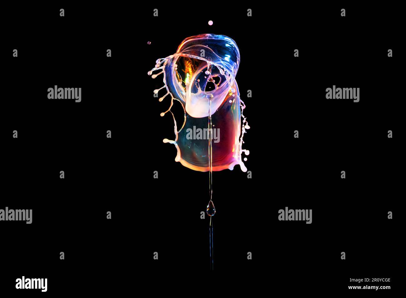 Falling drops of colored liquid, water splashes on a black background ...