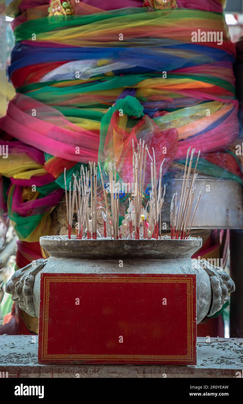 Incense Burning in an Incense Burner front of Fabrics Colorful wrapped ...