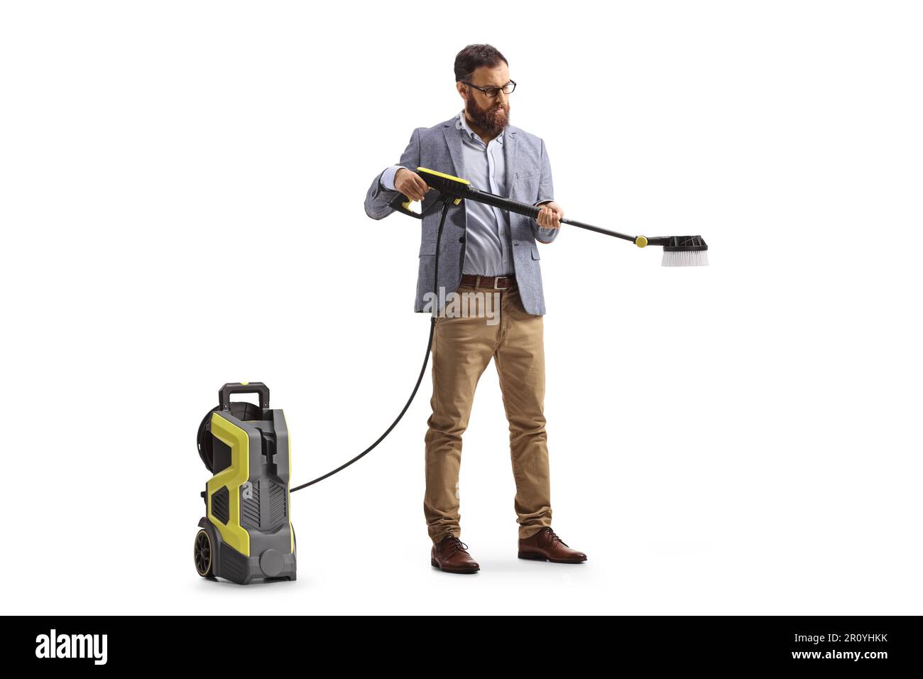 Full length profile shot of a man using a pressure washer with a brush ...