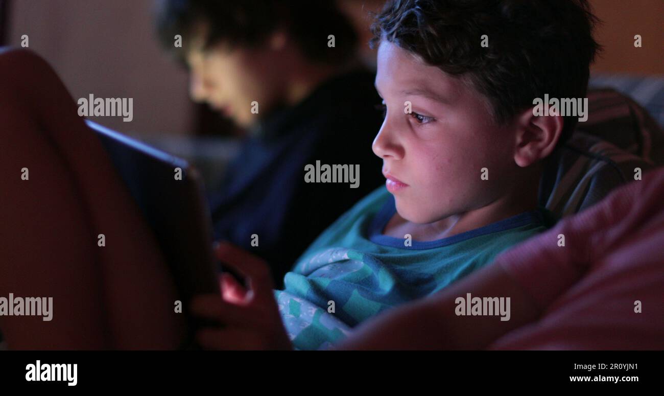 Child playing video-game on tablet device at night Stock Photo - Alamy