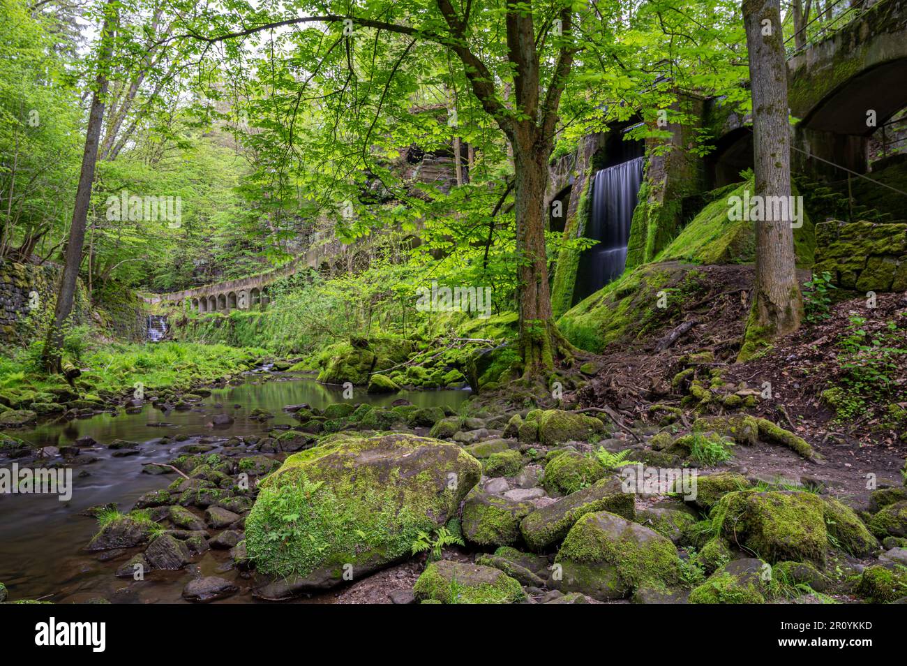 A picturesque waterfall cascading down a rocky cliff face surrounded by ...
