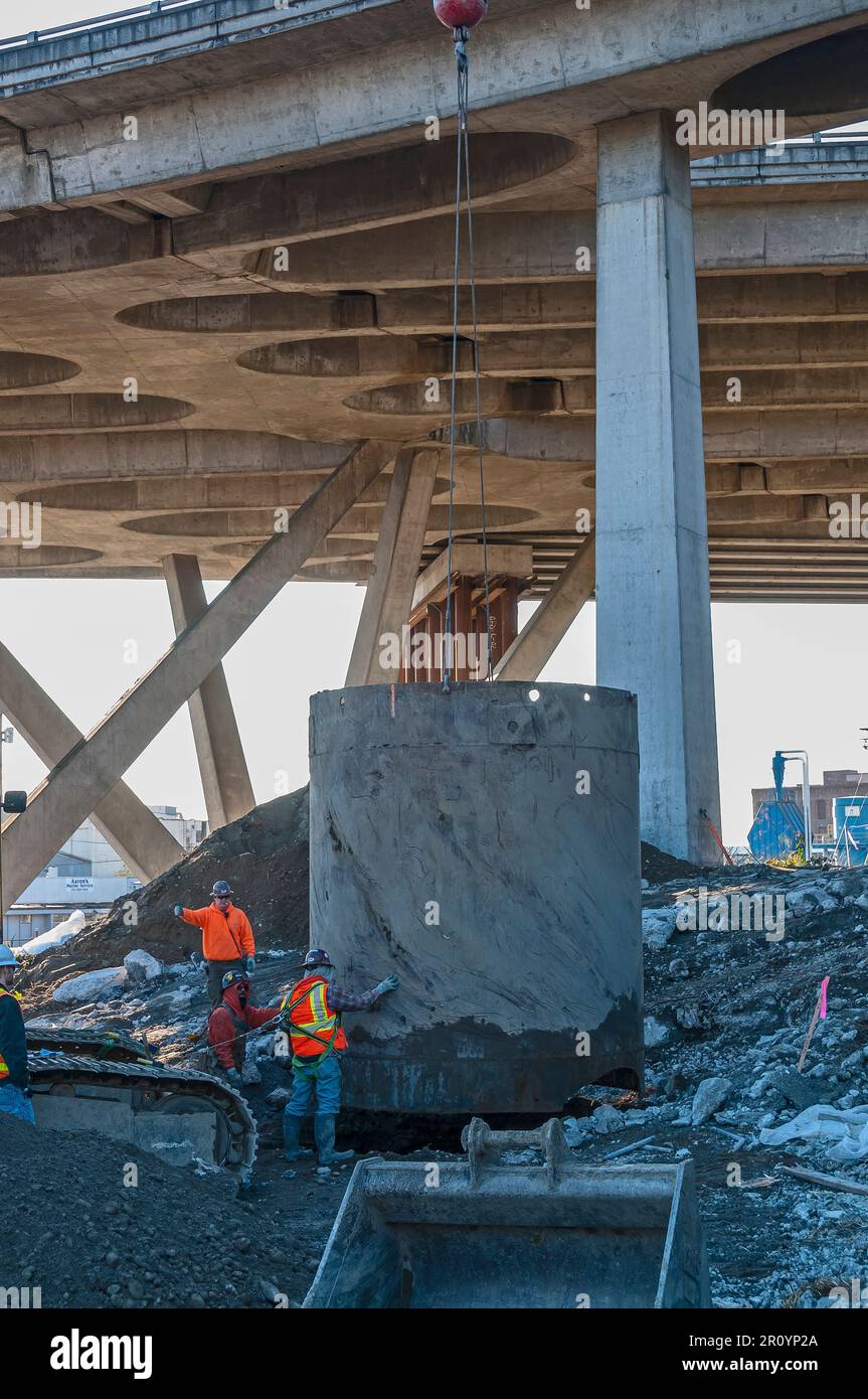 Workers work with pipe casing (caisson) for drilled shaft to support ...