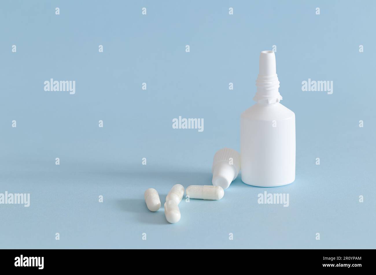 A bottle of nasal spray with the cap removed and some medication ...