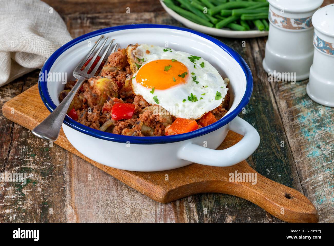 Corned beef hash with fried egg and green beans Stock Photo - Alamy