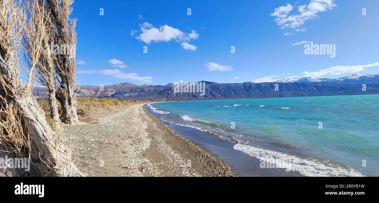 A picturesque beach landscape featuring a sandy shoreline with blue ...