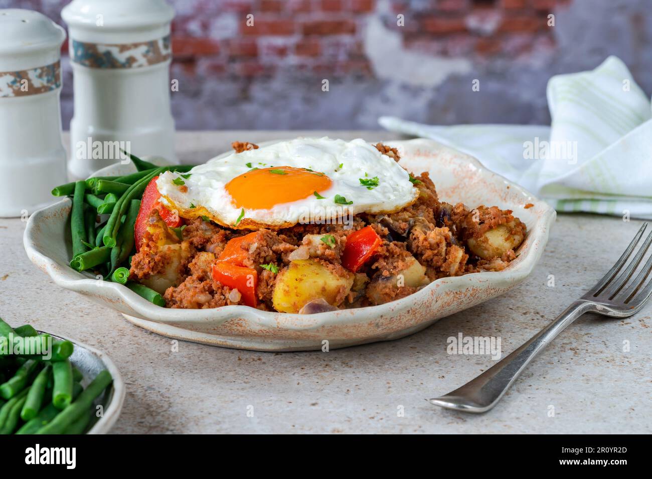 Corned beef hash with fried egg and green beans Stock Photo - Alamy
