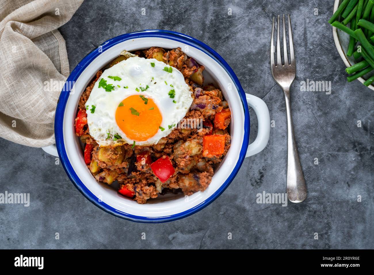 Corned beef hash with fried egg and green beans Stock Photo - Alamy