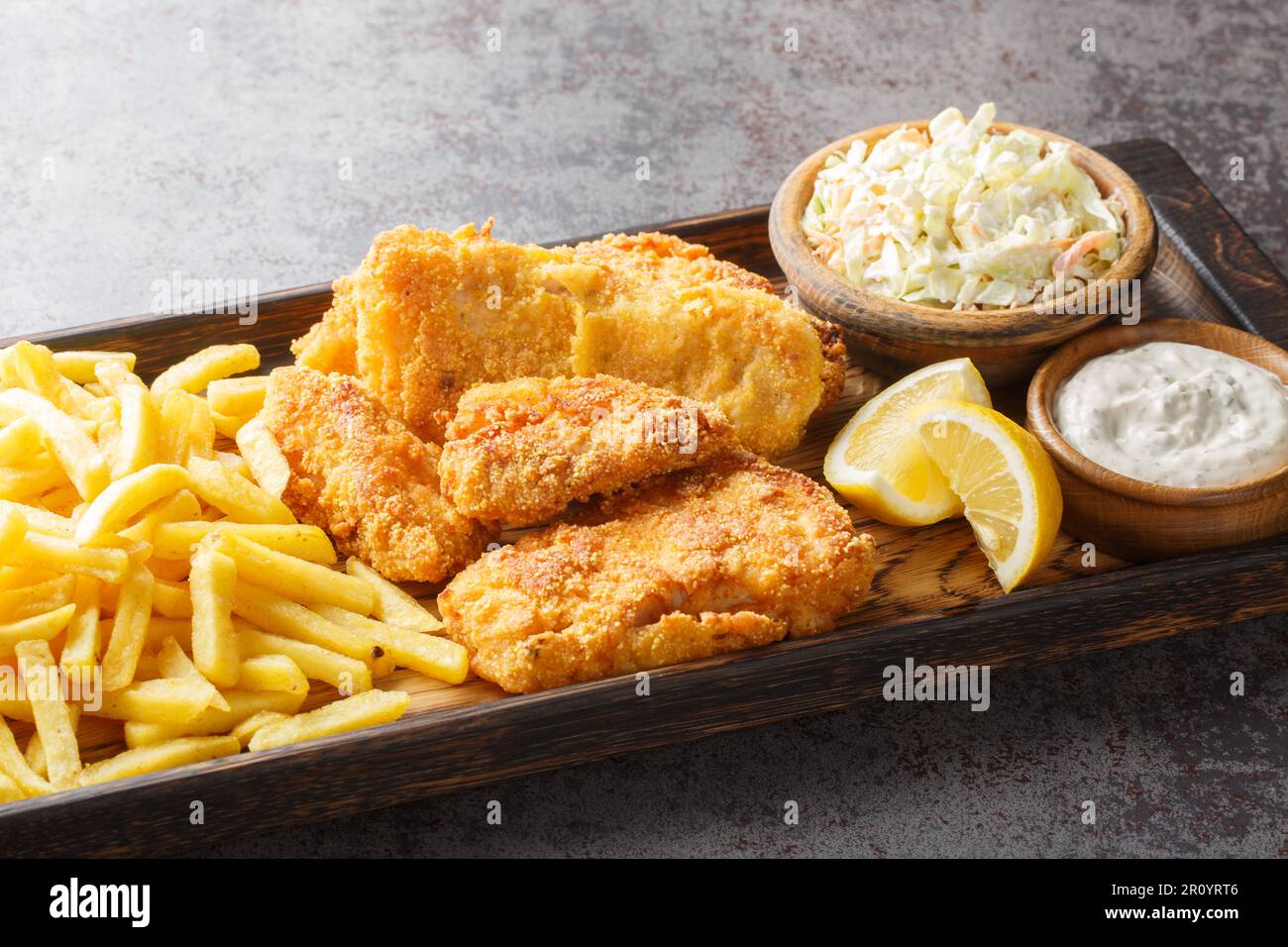 Tasty Fish Fry with coleslaw, French fries, tartar sauce and lemon ...