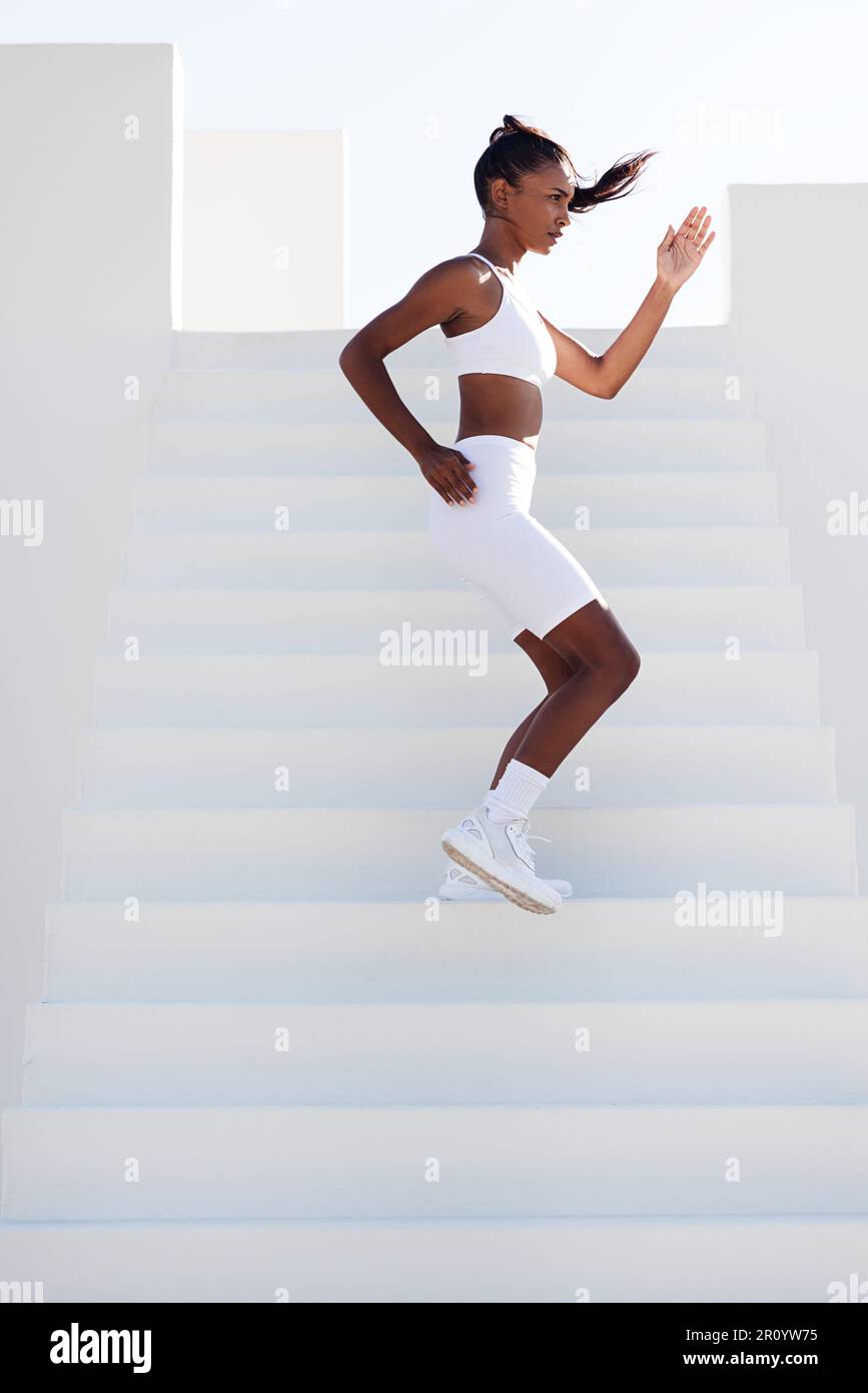 Full length of a slim female stepping down stairs outdoors. Young slim ...