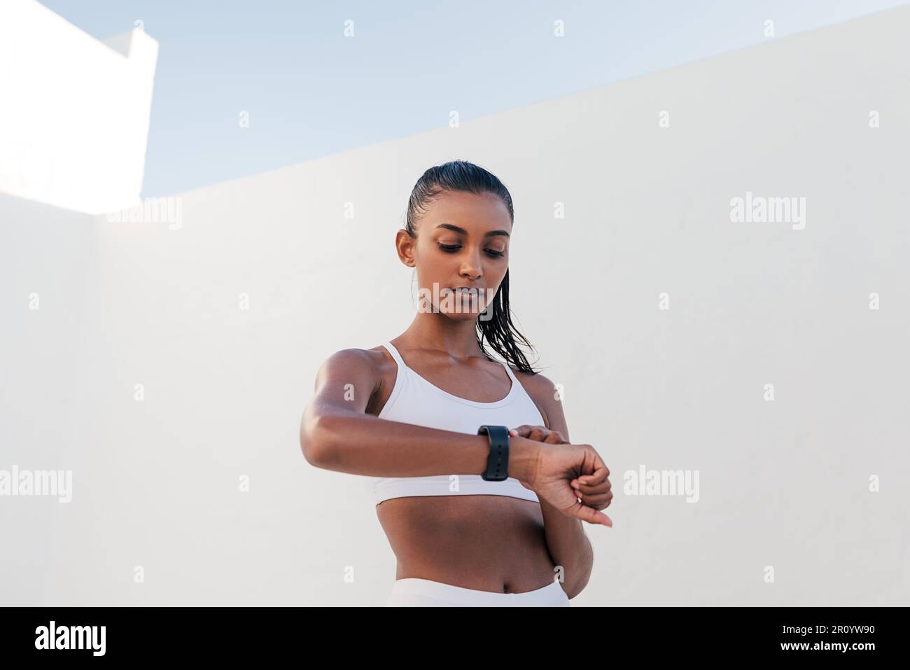 Slim female checking pulse on a smartwatch. Fitness influencer checking ...