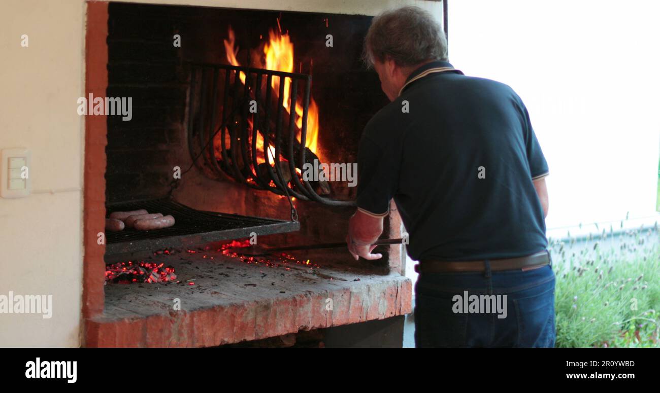 Man preparing barbeque parilla. Casual candid senior person cooking ...
