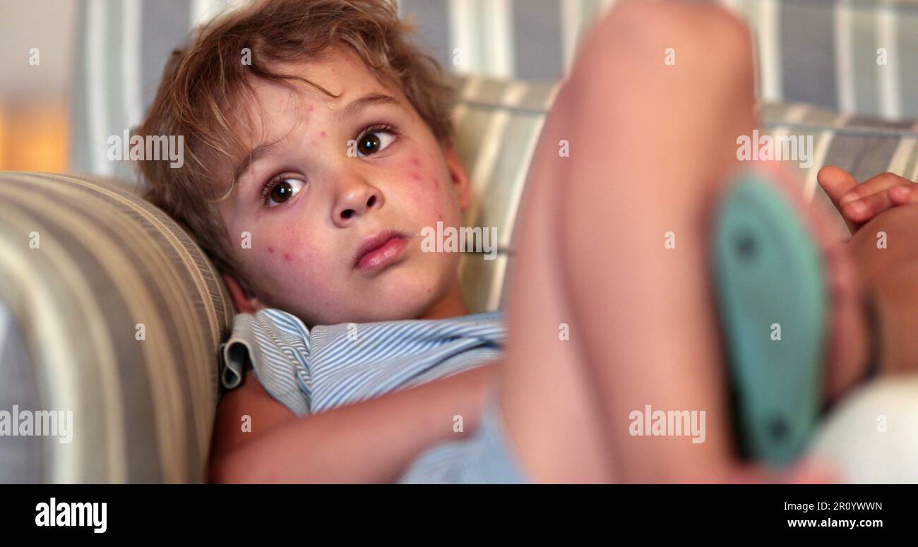 Cute infant toddler child watching TV at night. Candid casual child ...