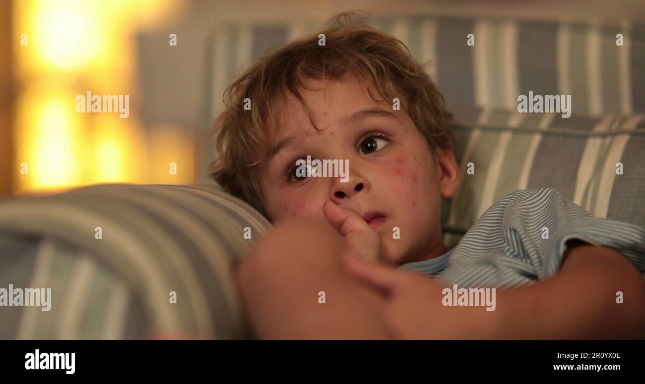 Cute toddler infant boy at couch in the evening watching TV Stock Photo ...