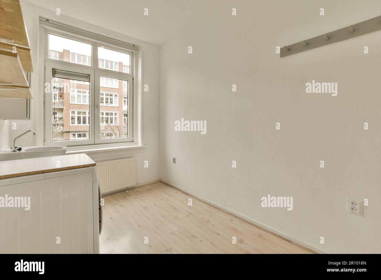 an empty kitchen with wood flooring and white walls in a room that has ...