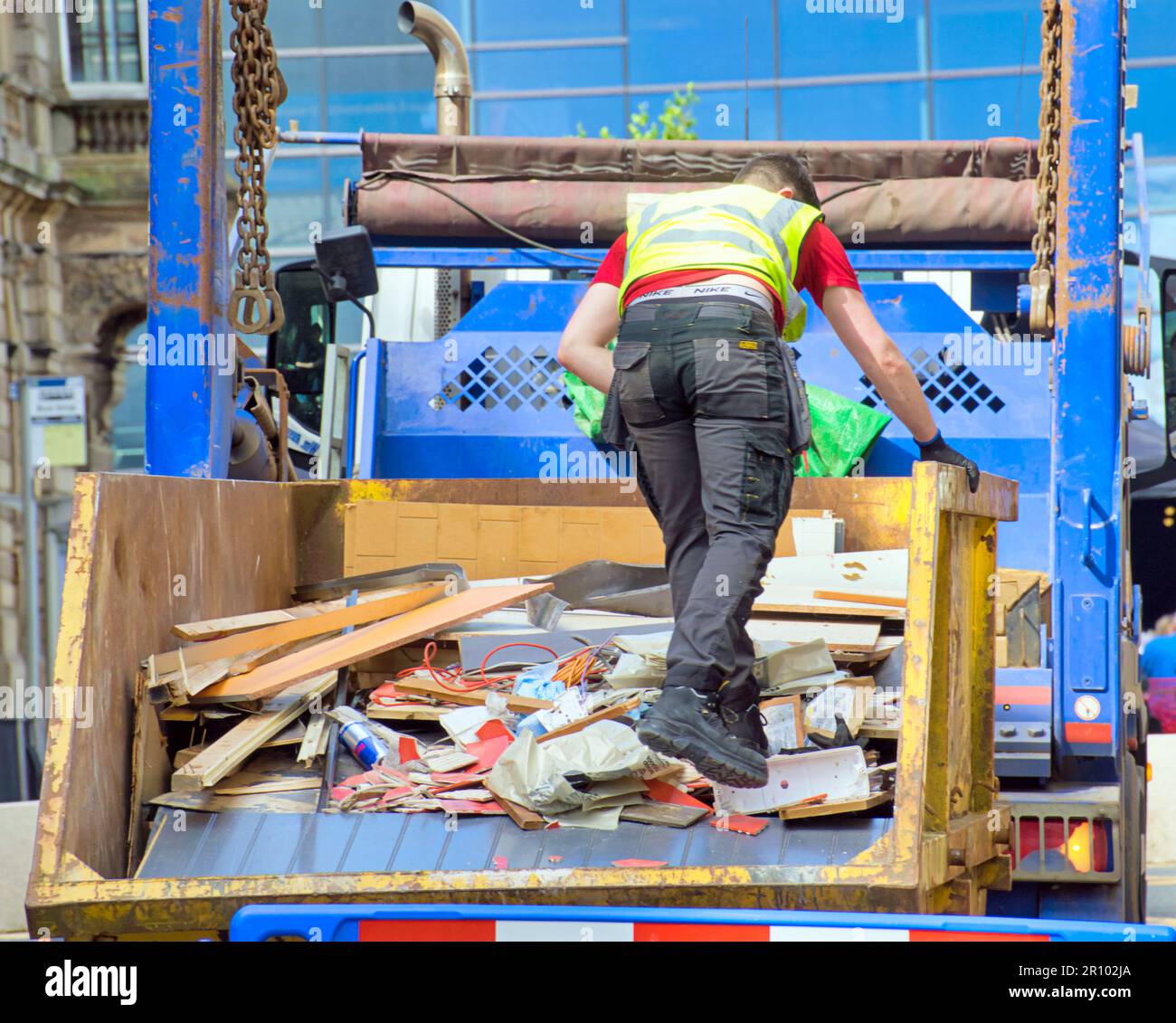 worker loading skip on back of lorry Stock Photo - Alamy