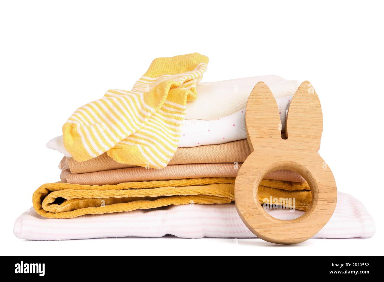 Stack of baby clothes and wooden toy isolated on white background Stock ...