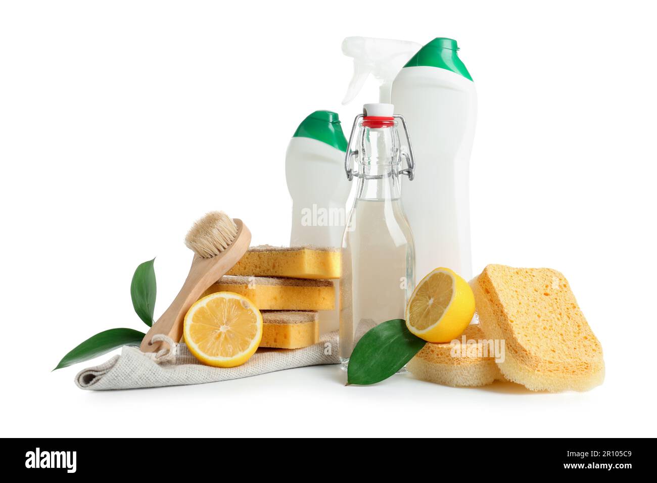 Bottles of vinegar, detergents, lemons, brush and sponges on white ...