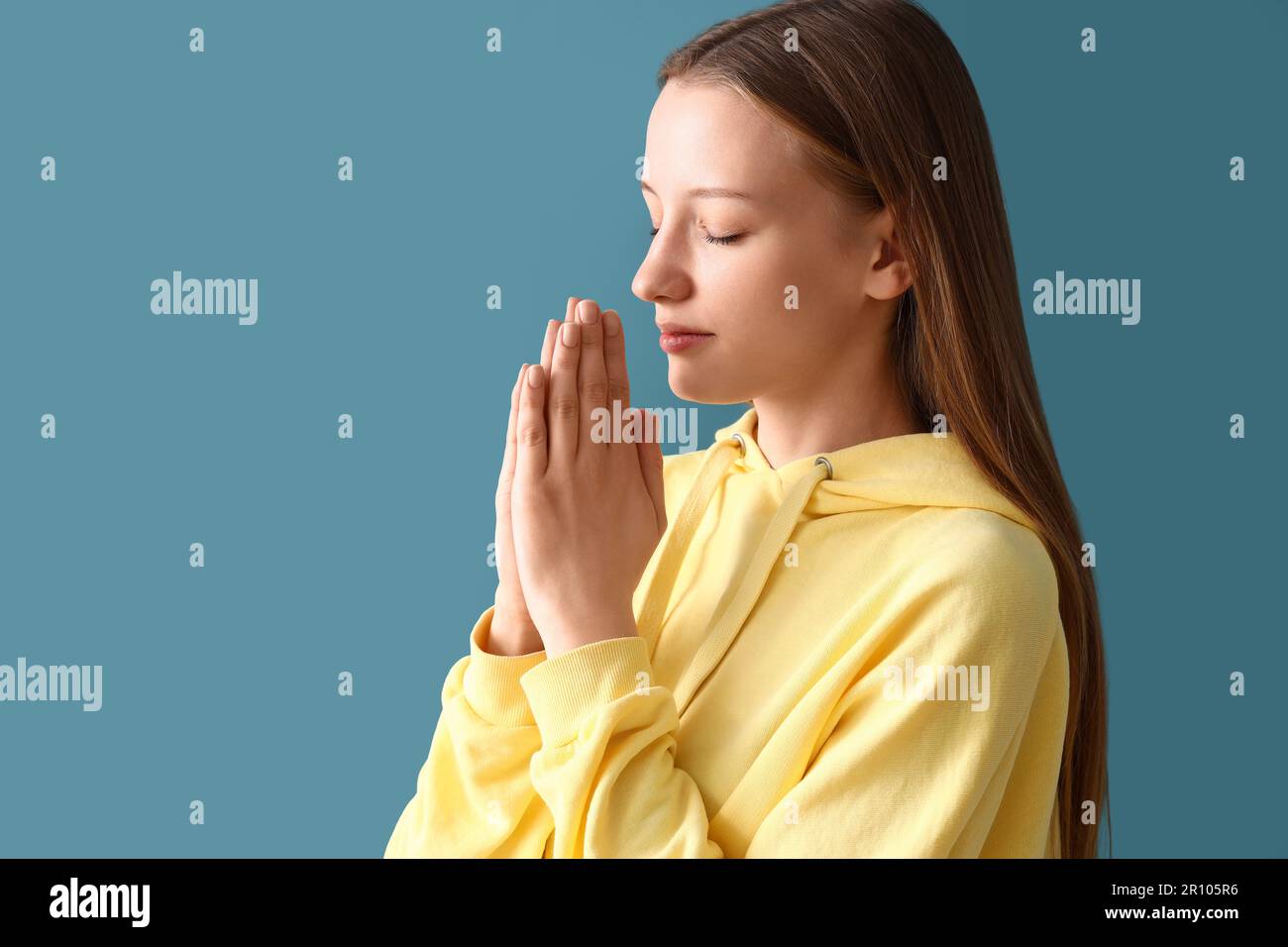 Teenage girl praying on blue background, closeup Stock Photo - Alamy