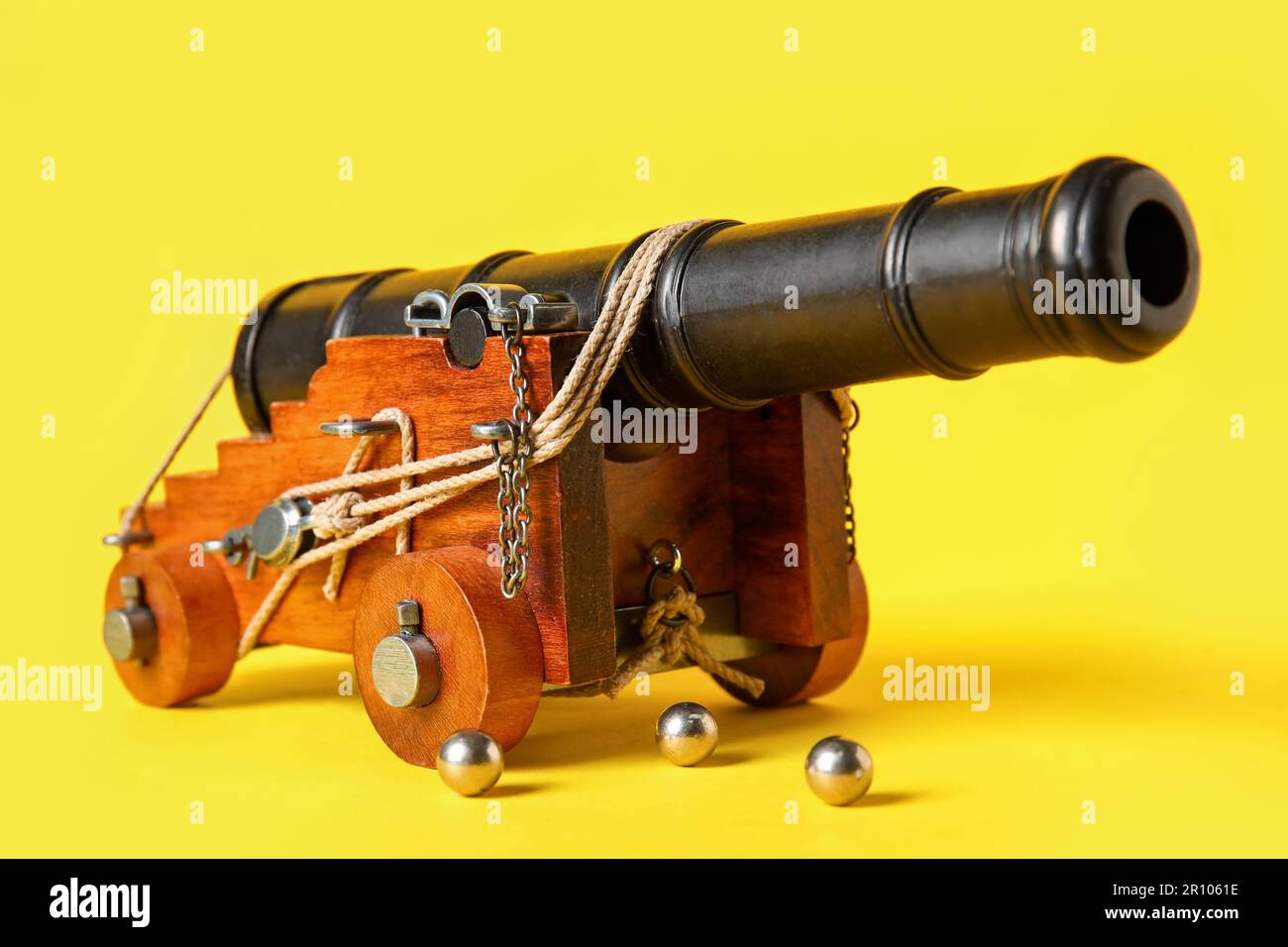 Toy model of cannon on yellow background Stock Photo - Alamy