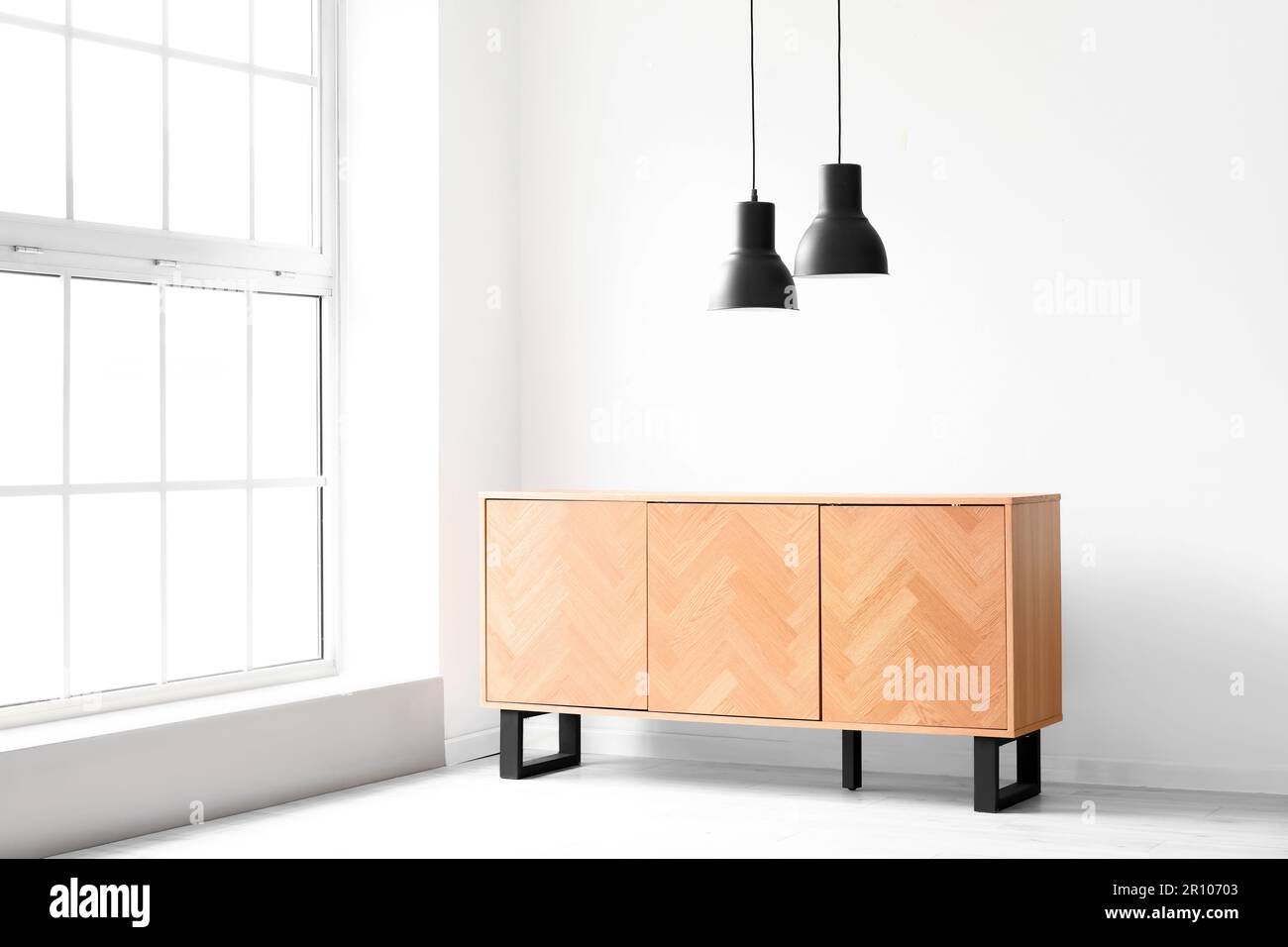 Stylish wooden cabinet near big window Stock Photo - Alamy