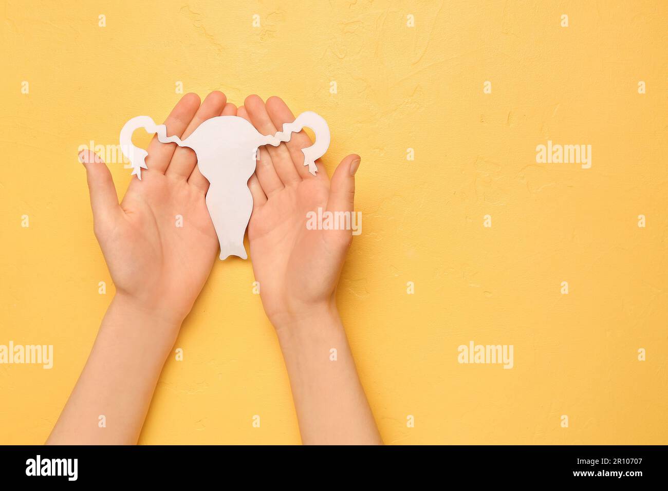 Woman with paper uterus on yellow background. Hormones concept Stock ...