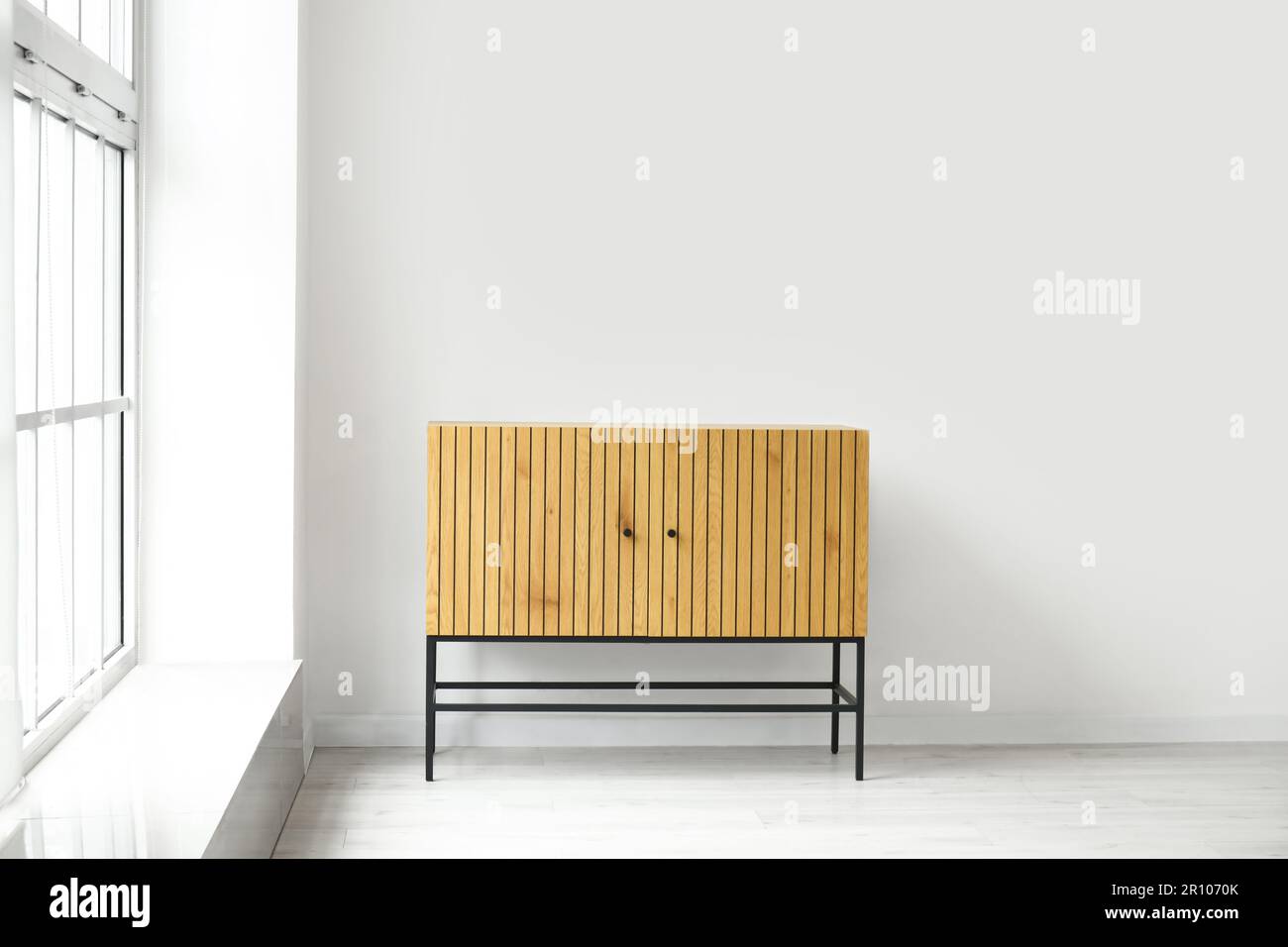 Stylish wooden cabinet near big window Stock Photo - Alamy