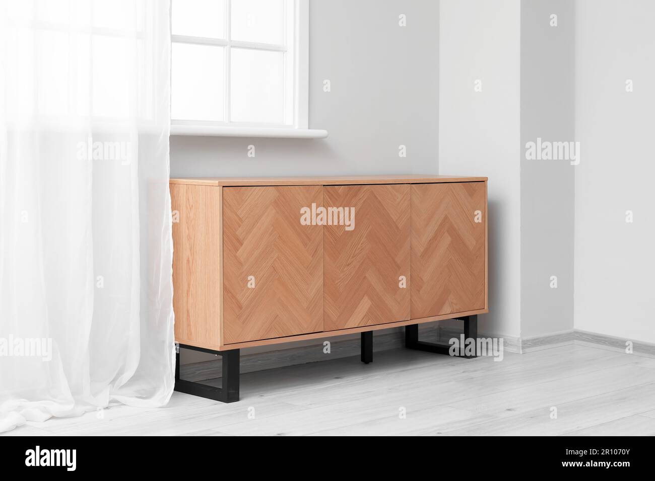 Stylish wooden cabinet near window Stock Photo - Alamy