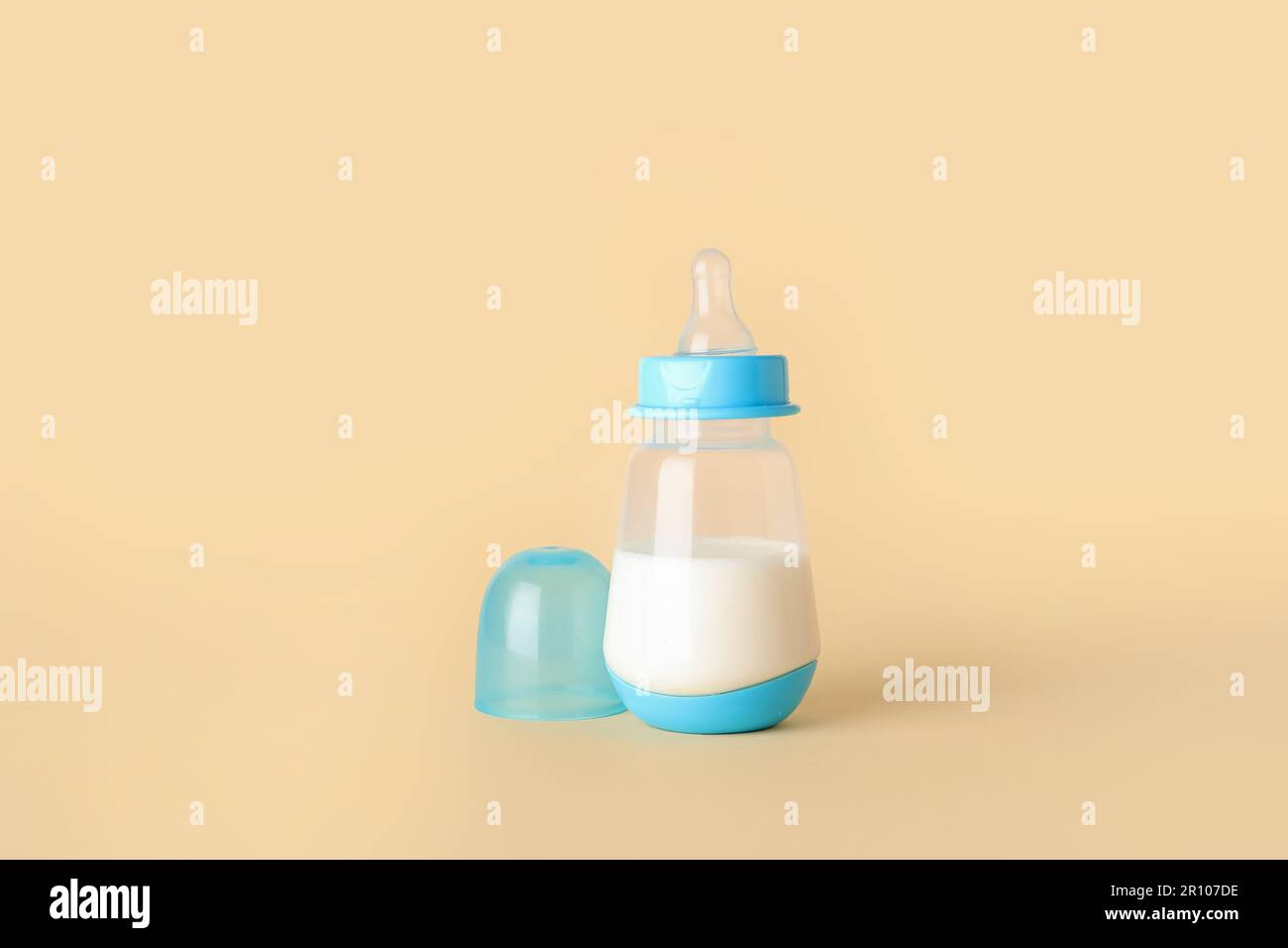 Bottle with milk for baby on pale yellow background Stock Photo - Alamy