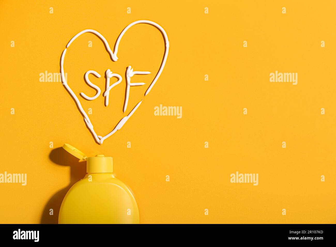 Drawing of heart and word SPF made with sunscreen cream on orange ...