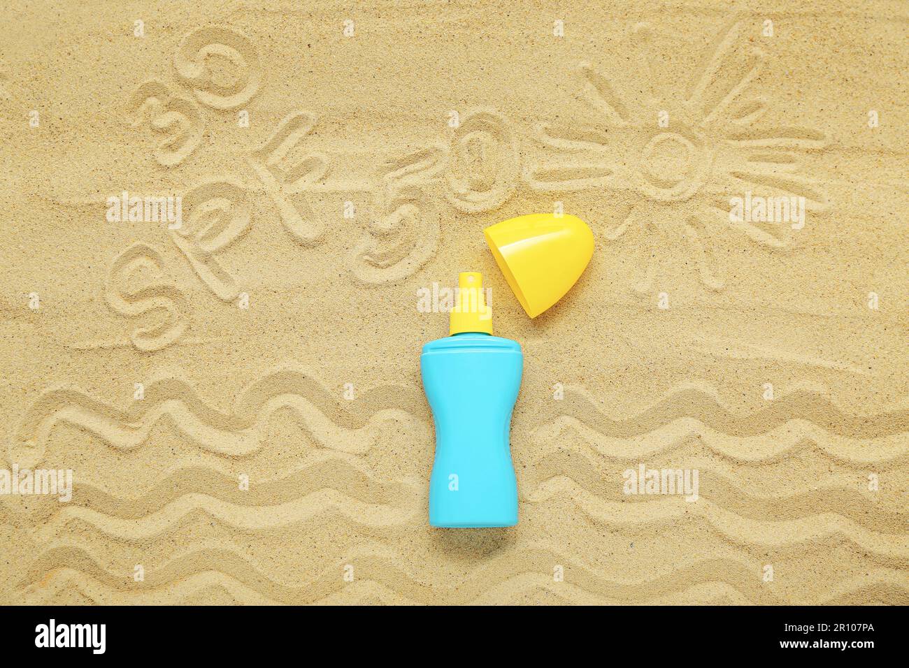Creative composition with sunscreen cream and drawings on sand Stock ...