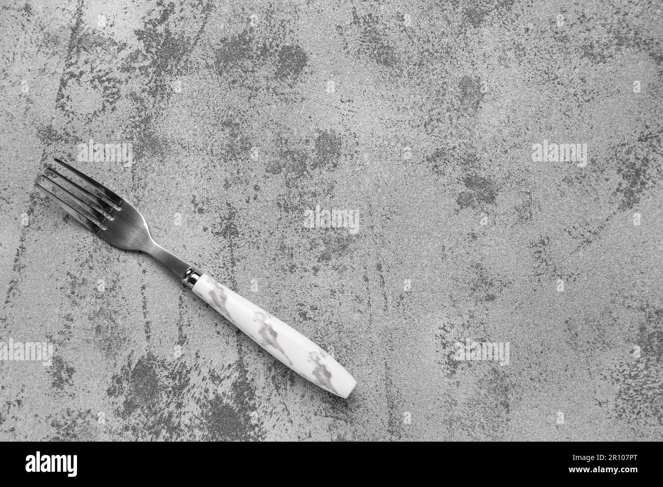 Stainless steel fork with plastic handle on grunge grey background ...
