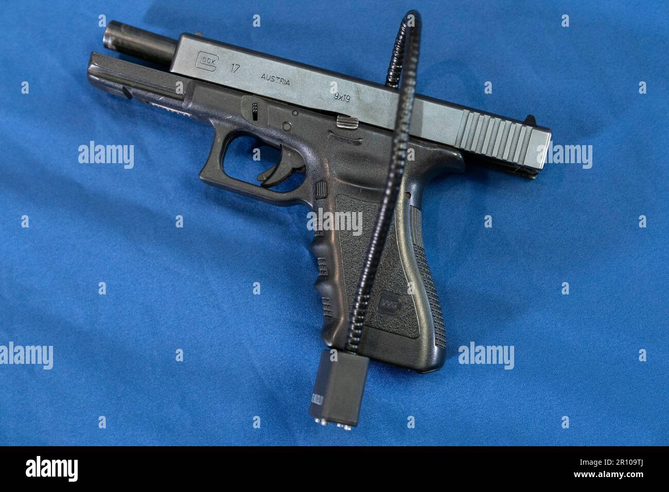 Displayed is a Glock 17 pistol fitted a with a cable style gun lock in ...