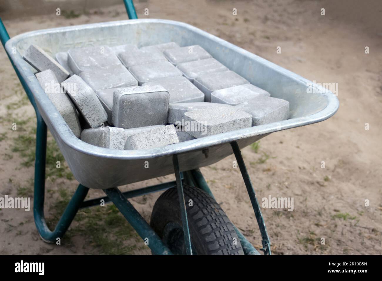 Defocus brick tiles stacked on a wheelbarrow. Gray pavement bricks for ...