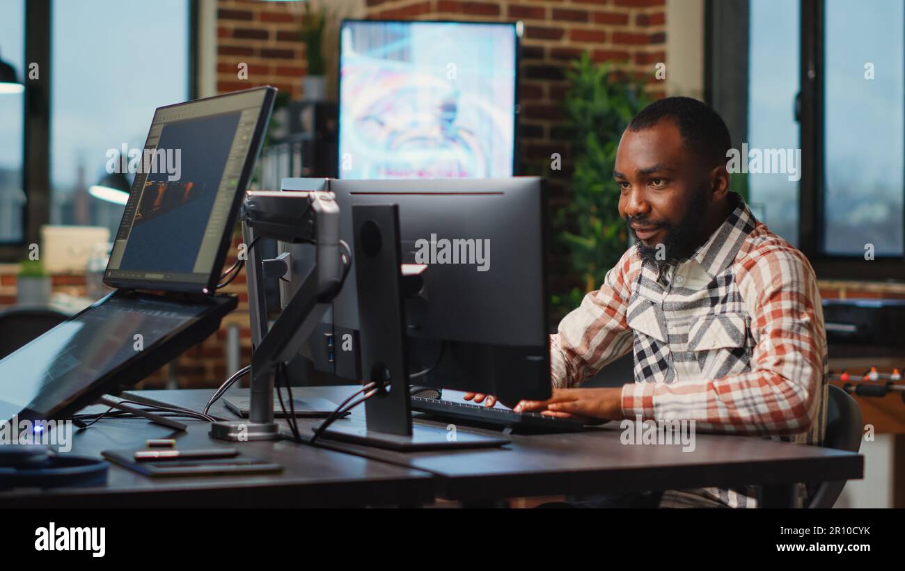 African american male artist working in studio office to create CGI production on software ...